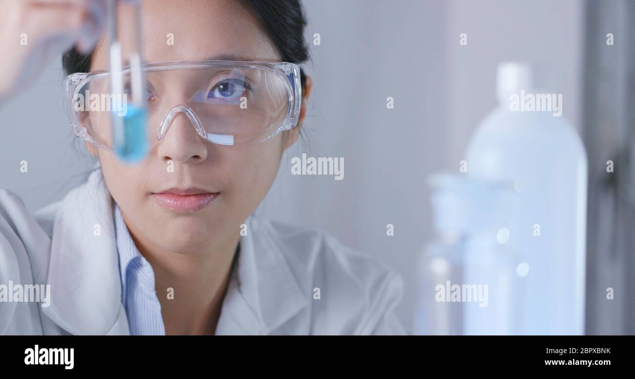 Scientist observation about test tube Stock Photo - Alamy