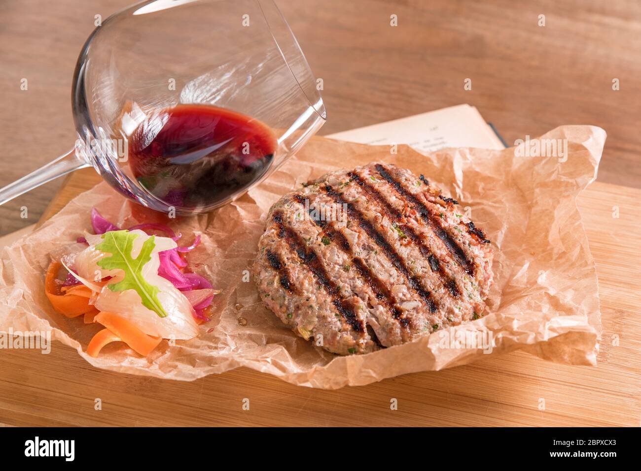 Homemade pork meatball served in a recycled paper on a wood board with ...