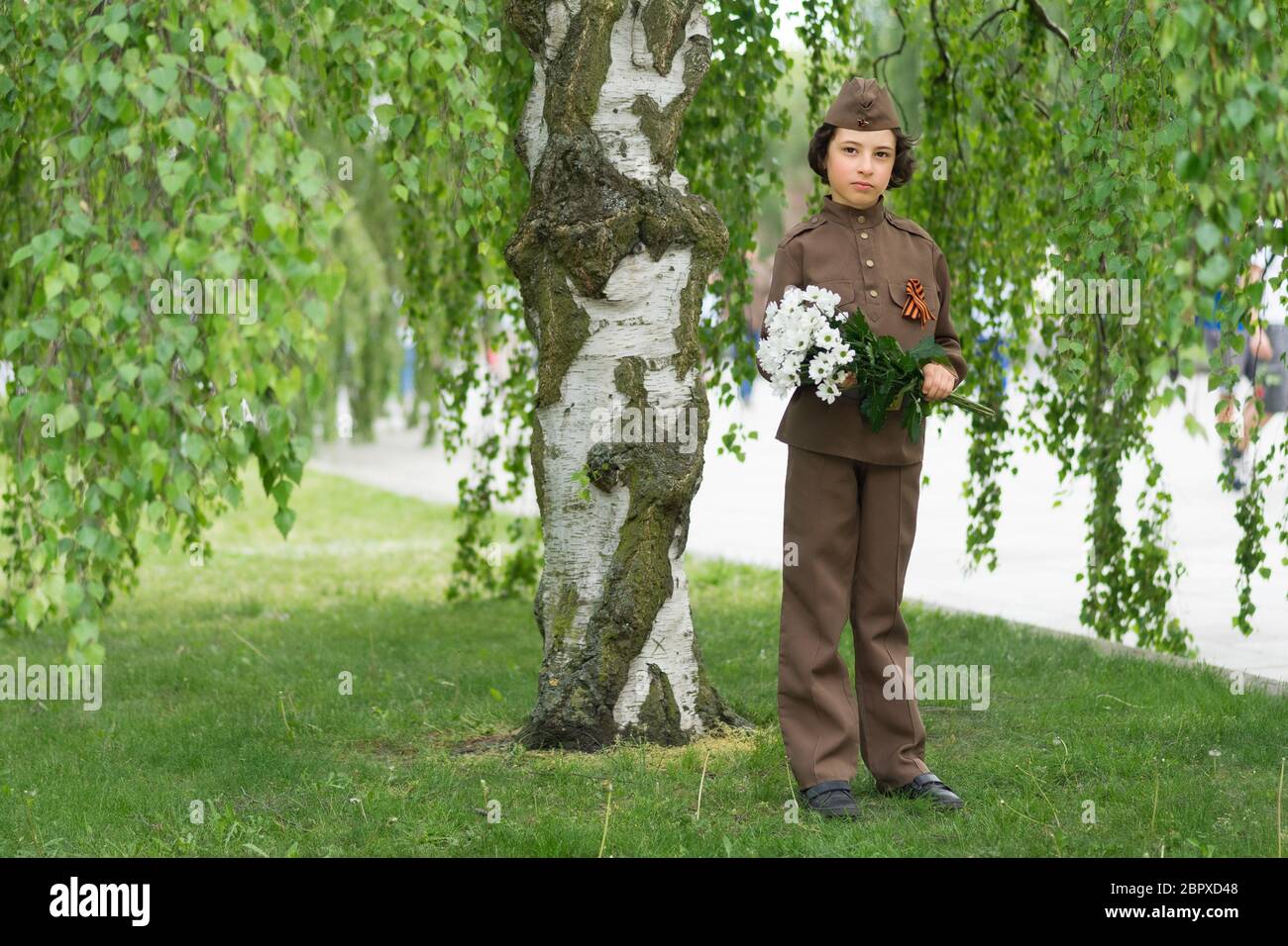 Portrait of a boy with flowers, in the uniform of a soldier of the Red ...