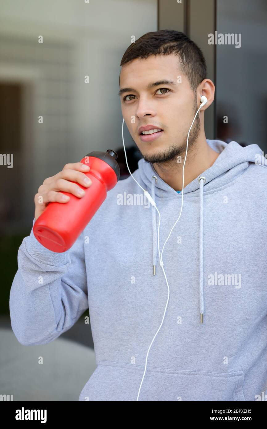 Drinking water young man runner running portrait format jogging sport ...