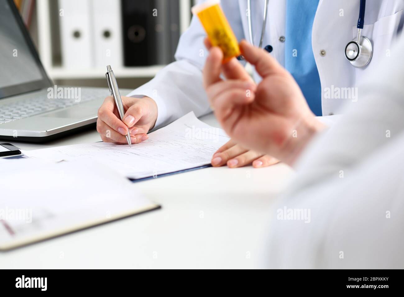 Female medicine doctor write prescription at worktable Stock Photo - Alamy