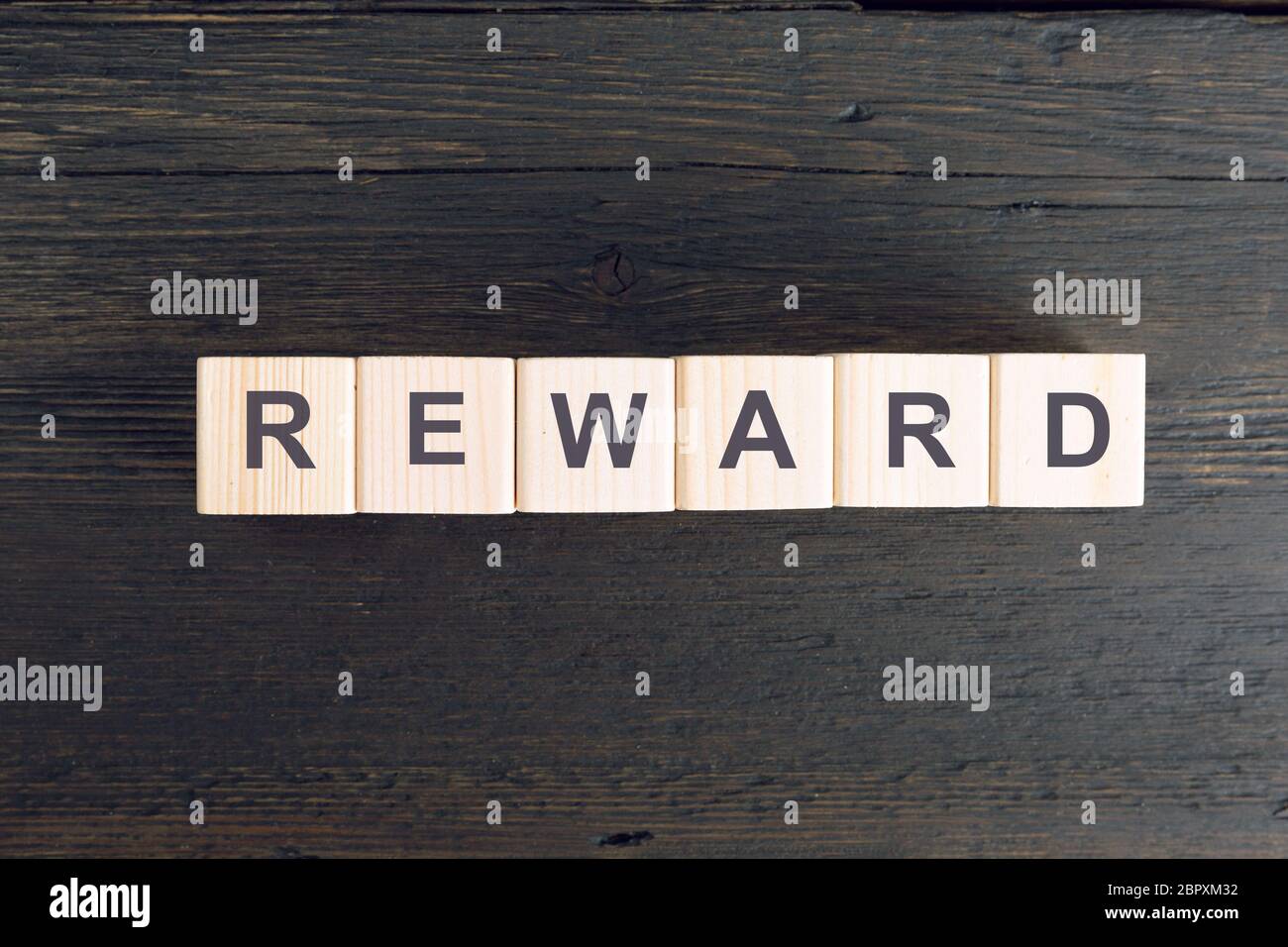Word REWARD written on a wooden cube. Risk and reward concept Stock ...