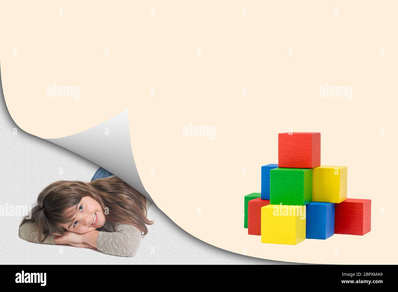 Blank yellow page with curl effect and smiling cute little girl lying ...