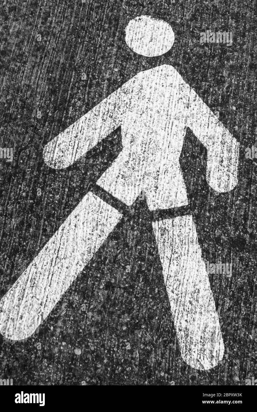 White Pedestrian Symbol on the gray asphalt. Roadsign Stock Photo - Alamy