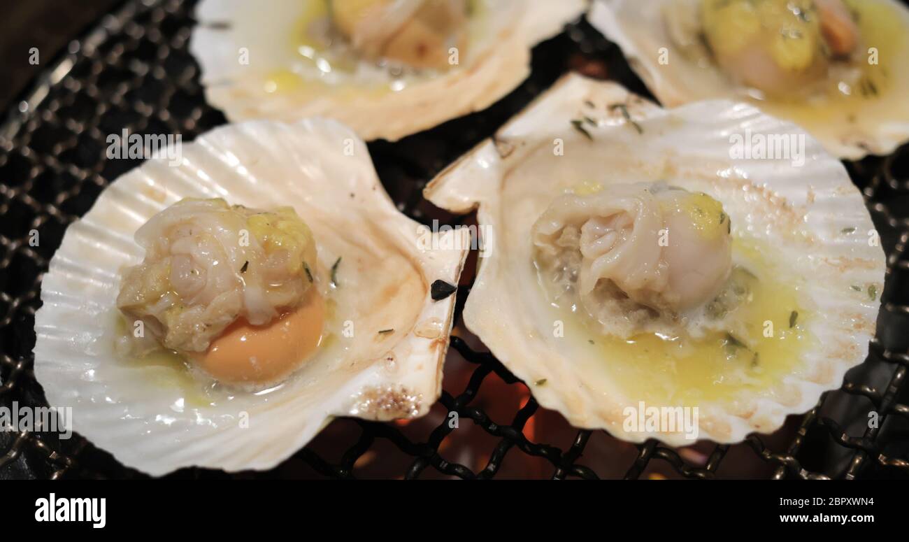 Scallop on metal net barbecue in restaurant Stock Photo - Alamy