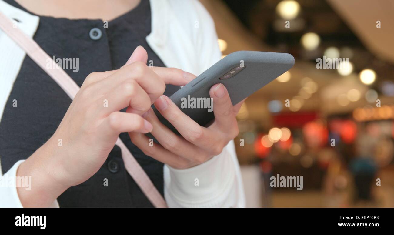 Woman use of smart phone inside shopping center Stock Photo - Alamy
