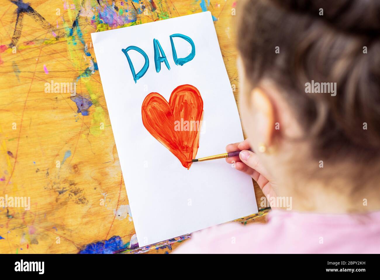 Hand of child drawing red heart with word Dad greeting card by ...