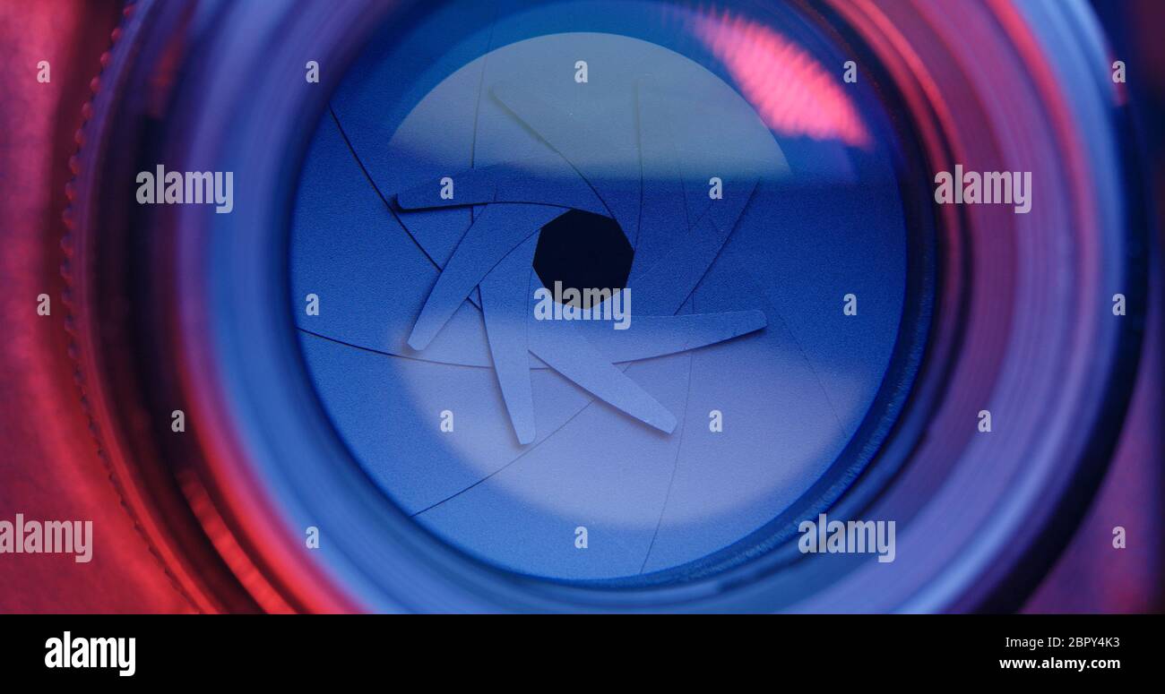 Adjusting Camera lens aperture with pink and purple light Stock Photo ...