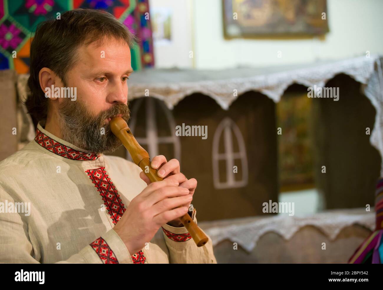 Slavic man plays an ethnic pipe. Belarusian musician in national ...