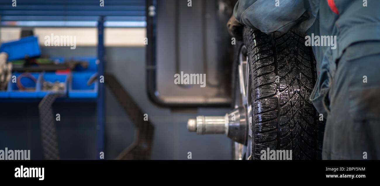 Mechanic changing a wheel of a modern car (color toned image Stock ...