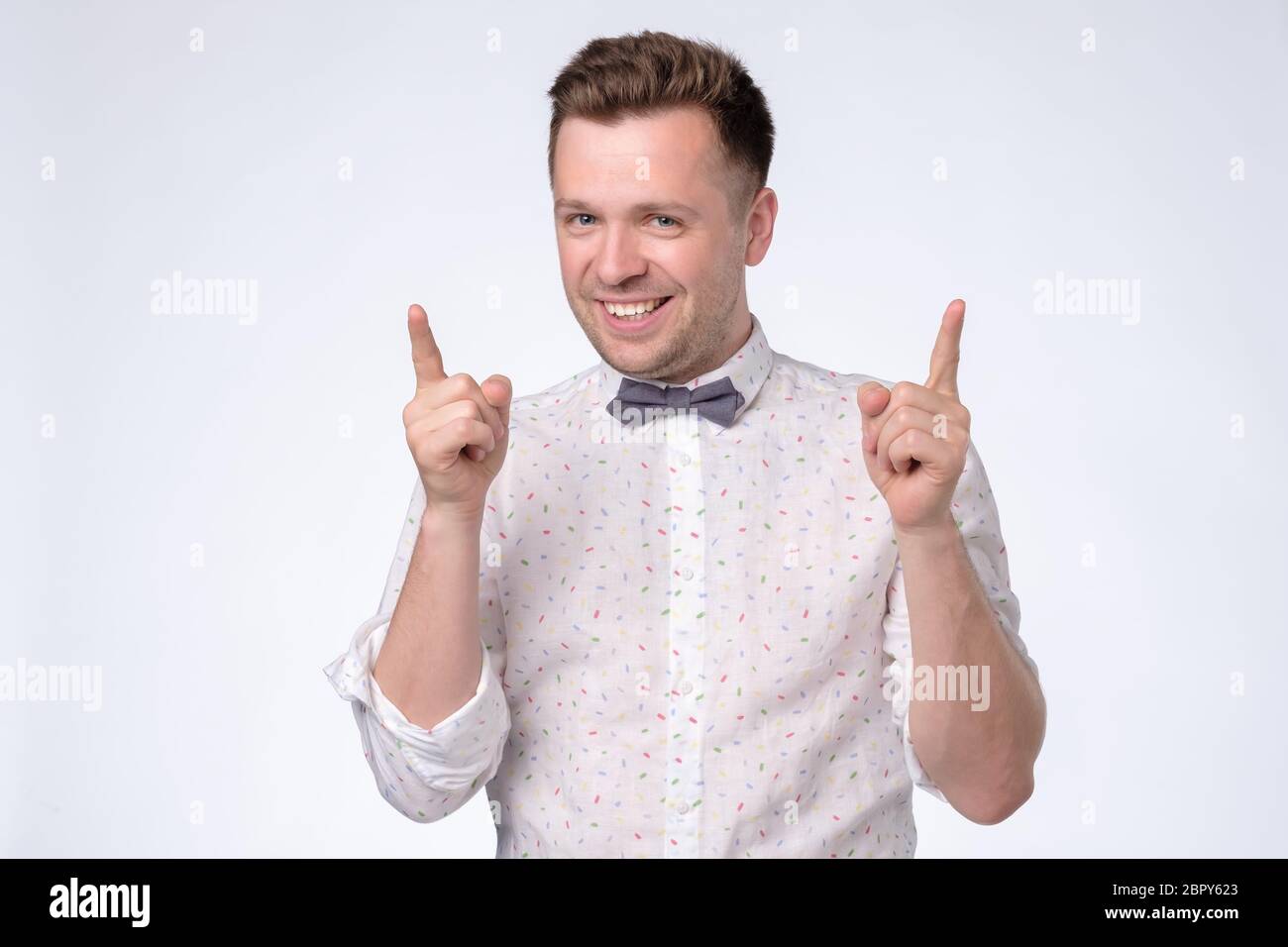 Excited young guy raising his index finger up. Studio shot Stock Photo ...