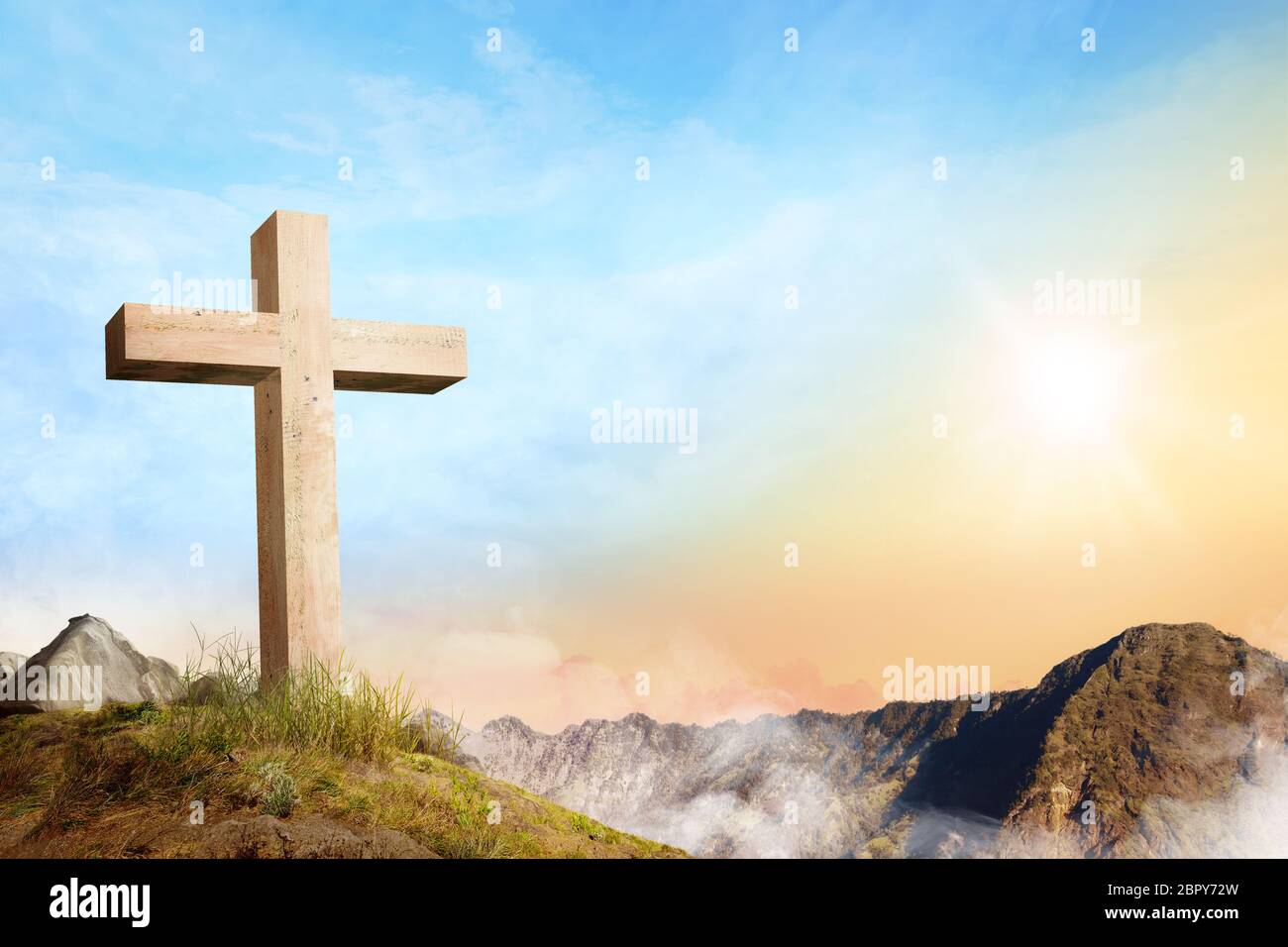 Christian cross on the of mountain with clouds fog over sunrise ...