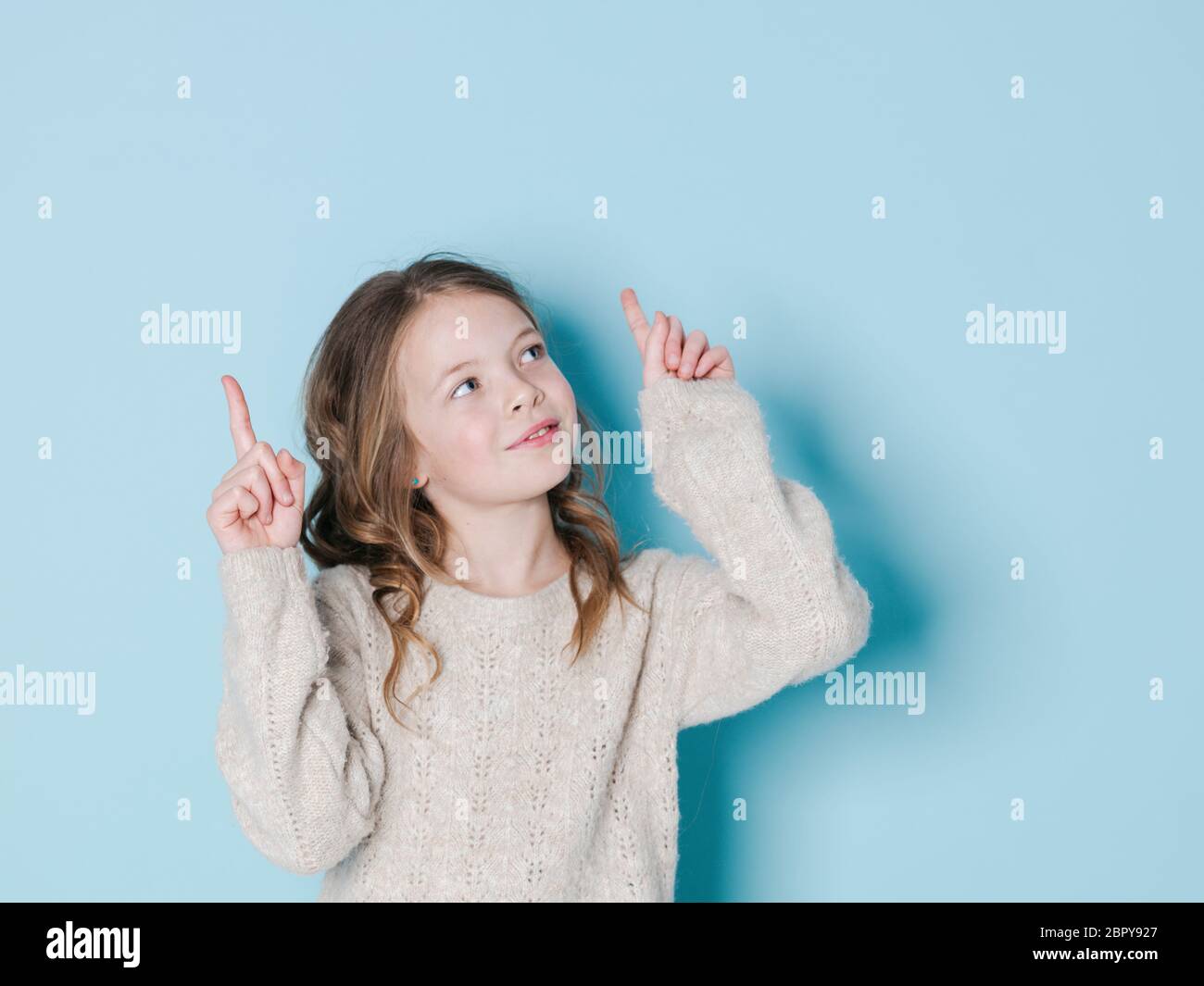 pretty and cool 9 year old girl with brown wool sweater posing in front ...