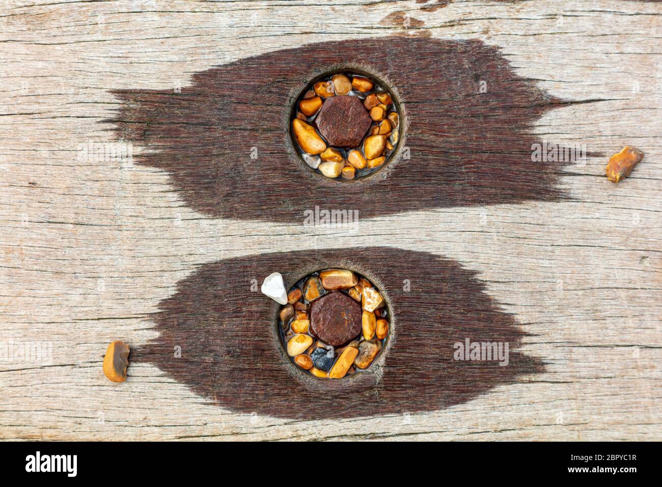 Small pebbles caught in the holes in a boat ramp on the beach at low ...