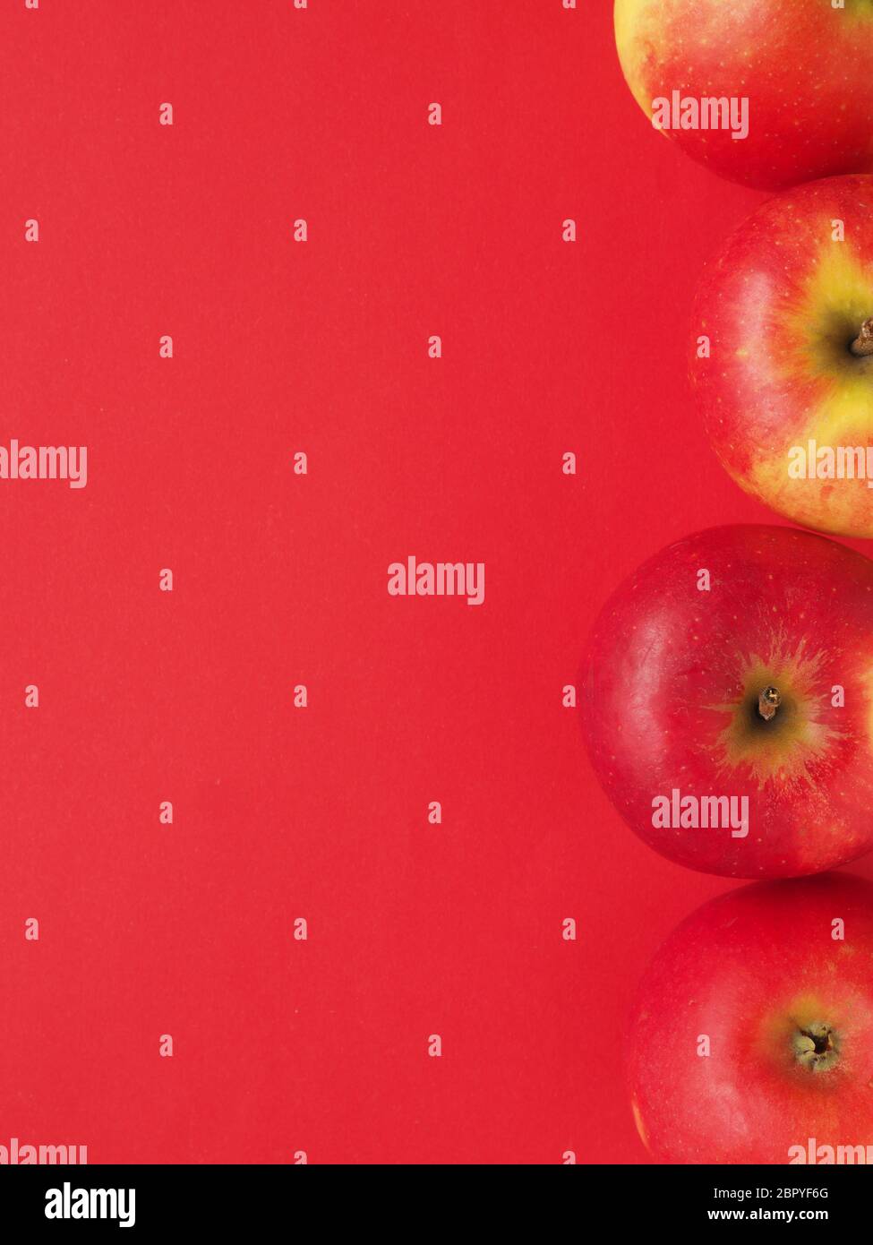 Red organic apples on a red background with space for text Stock Photo ...