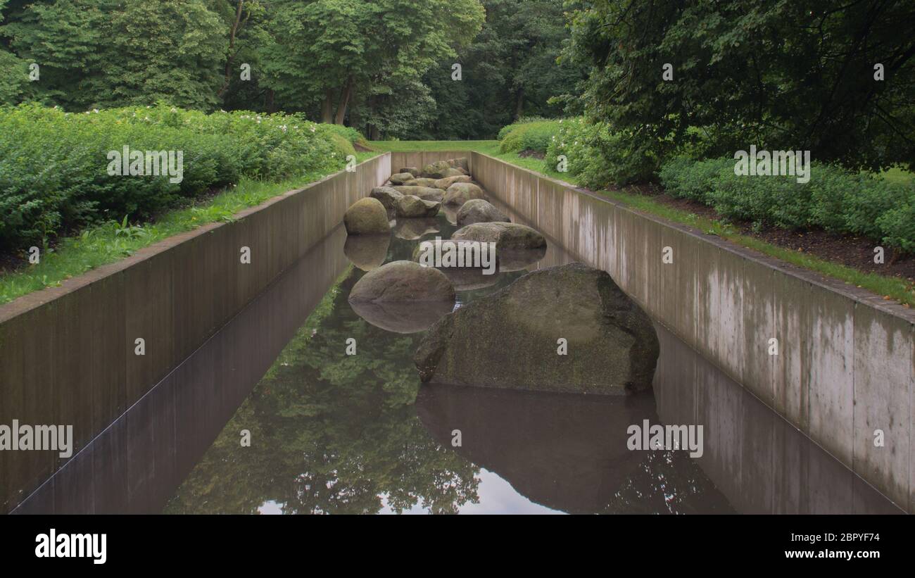 Pond channel with stones in park background Stock Photo - Alamy