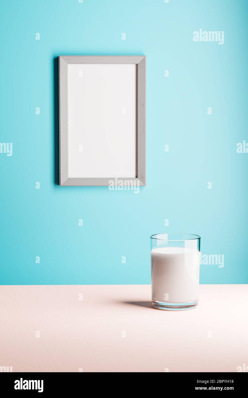 A glass of milk on a table. An empty wooden frame on the wall for use ...