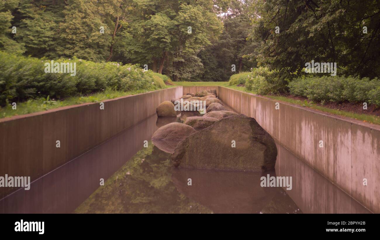 Pond channel with stones in park background Stock Photo - Alamy