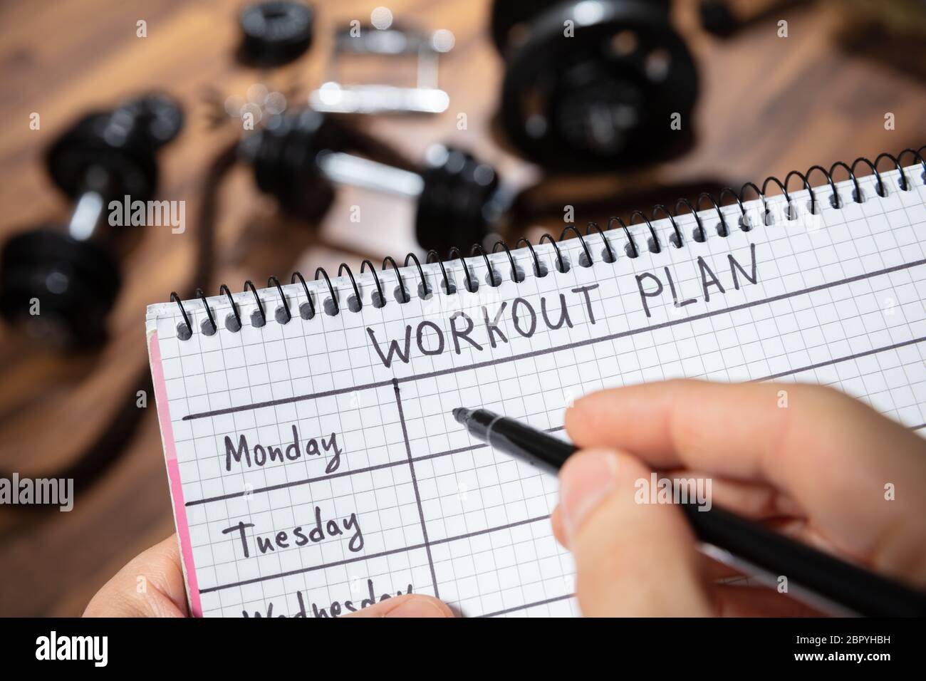 Close-up Of A Human's Hand Writing Workout Plan On Diary In The Gym ...