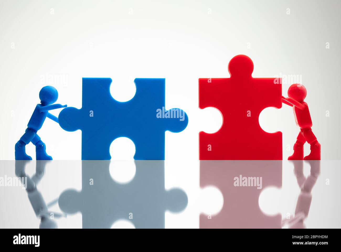 Side View Of Two Miniature Human Figures Solving Jigsaw Puzzles On ...