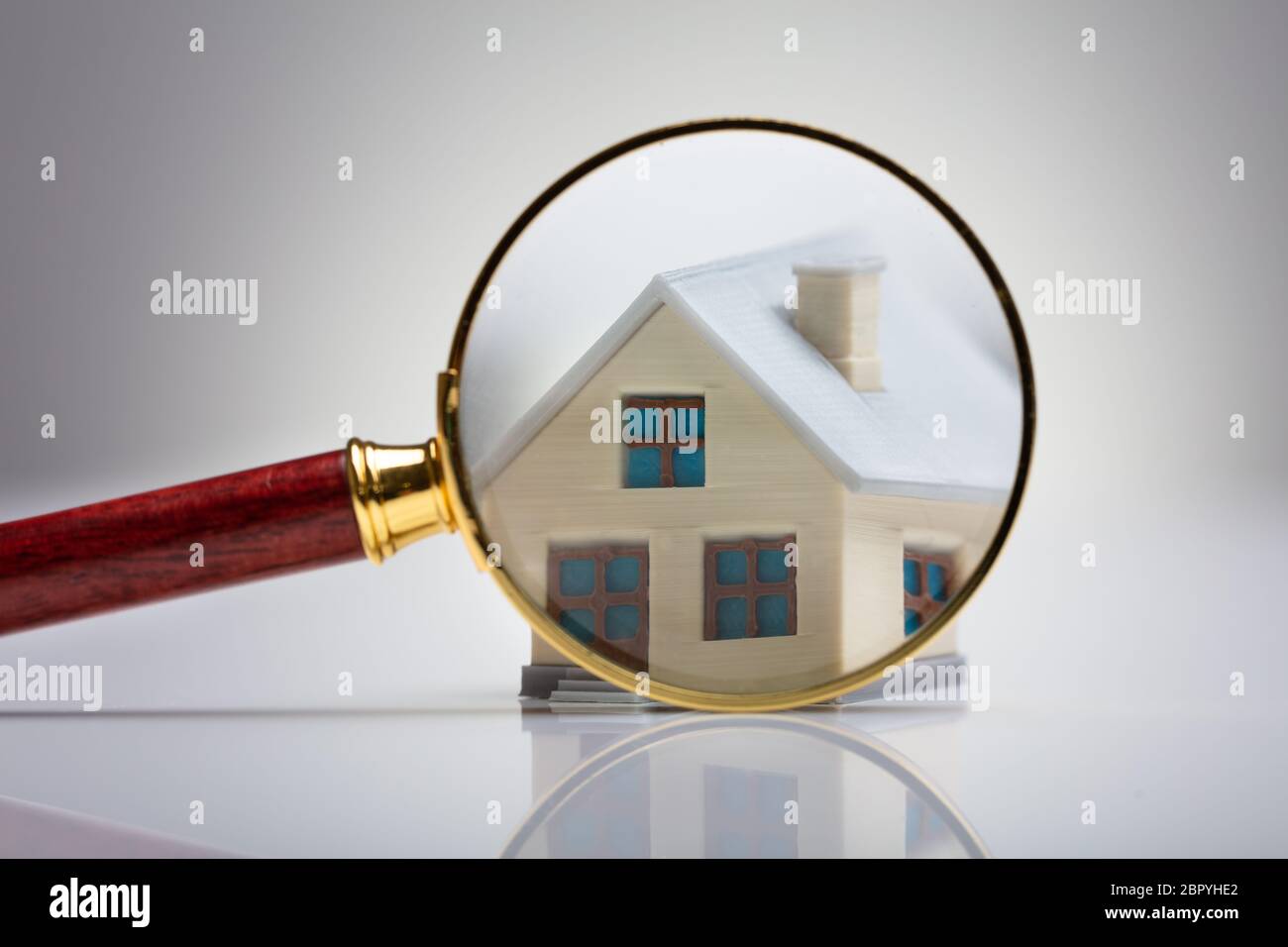 Close-up Of A House Model Seen Through Magnifying Glass On White Desk ...