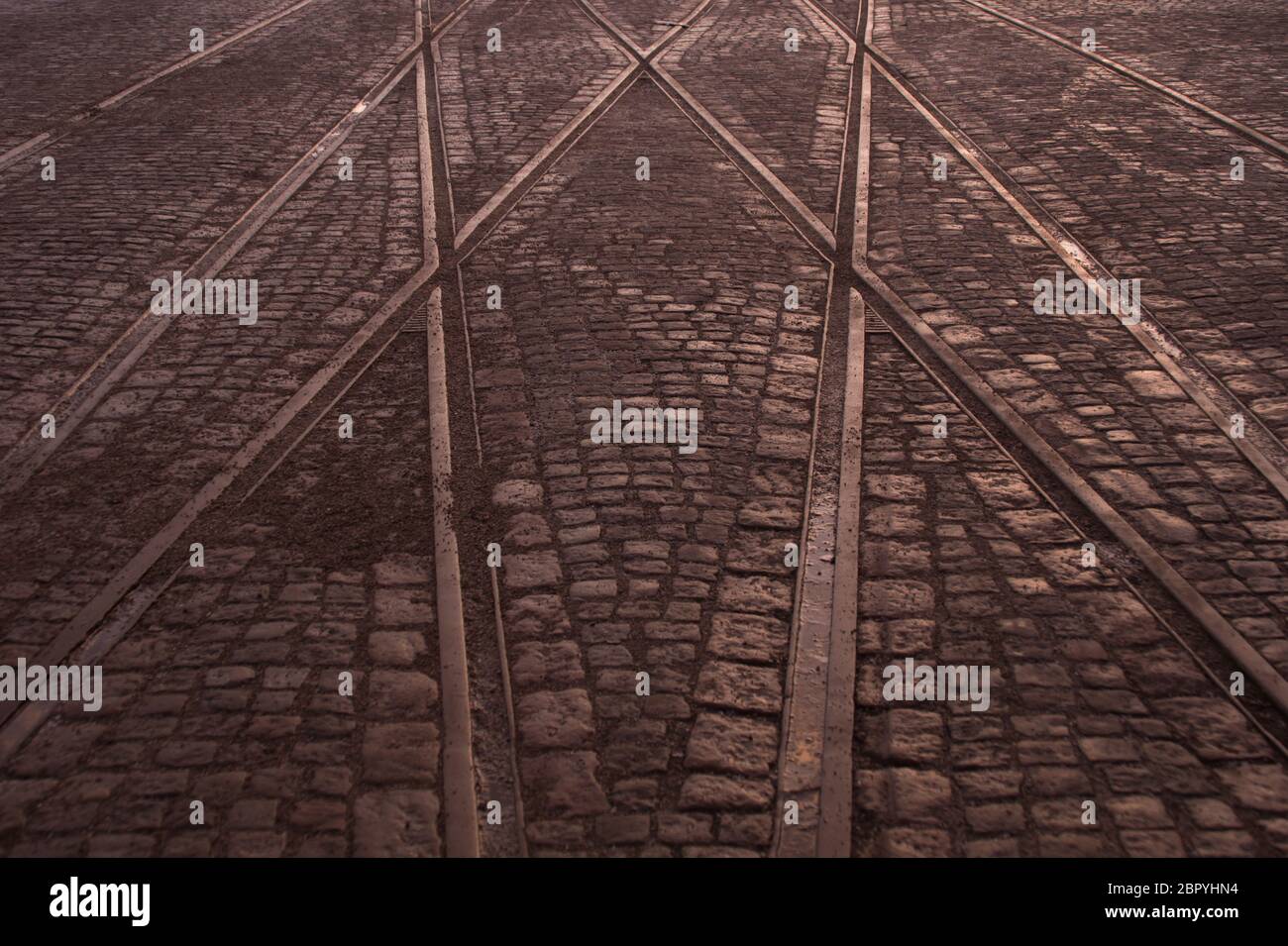 Crossing of tram rails on stone pavement background Stock Photo - Alamy