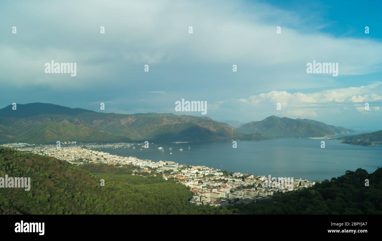 Nature landscape with a city by the shore of the sea between the hills ...