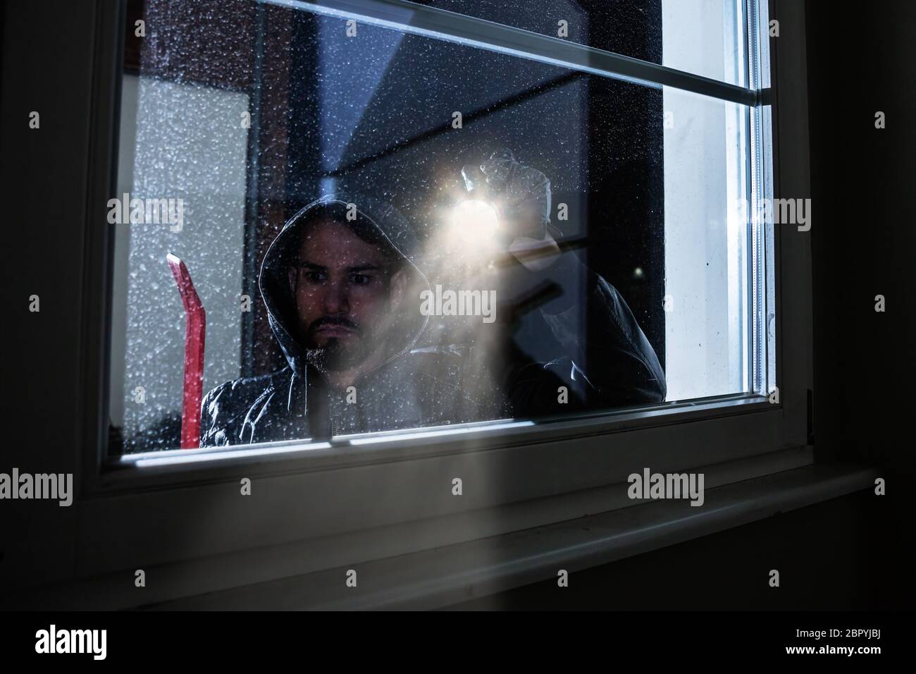 Burglar With Crowbar And Flashlight Looking Into A House Windows Stock ...