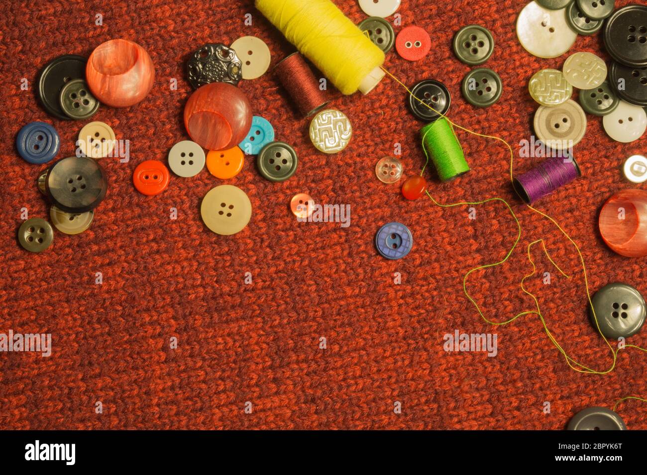 Various sewing buttons with the threads on textile background. copy ...