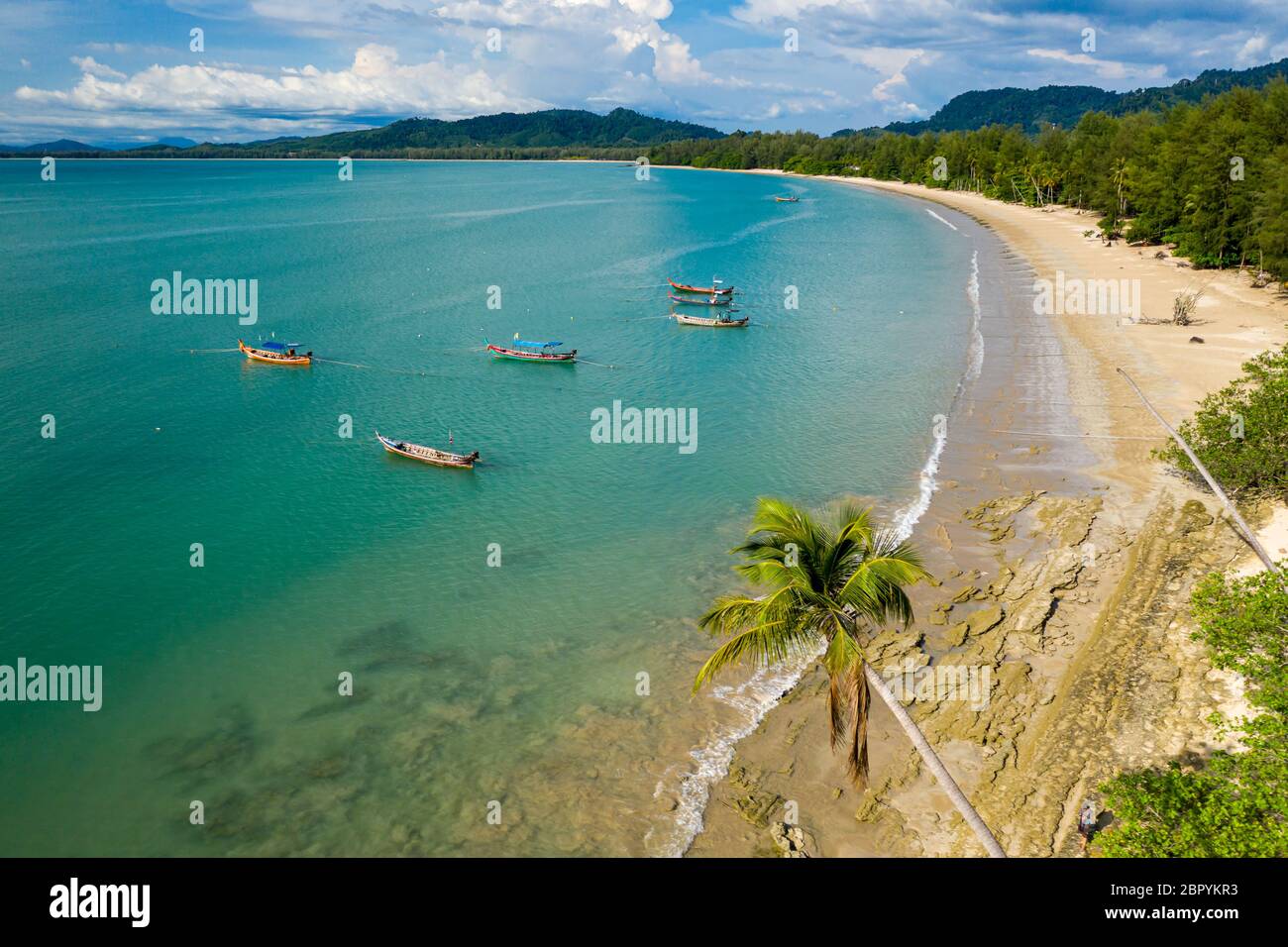 Aerial view of a beautiful, empty tropical beach surrounded by palm ...