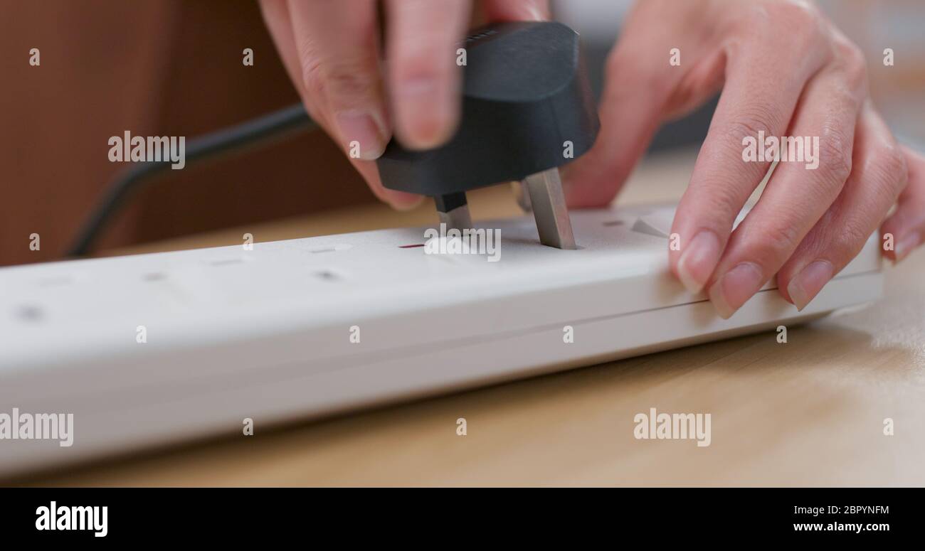 Woman plug in the power cord on power socket Stock Photo - Alamy