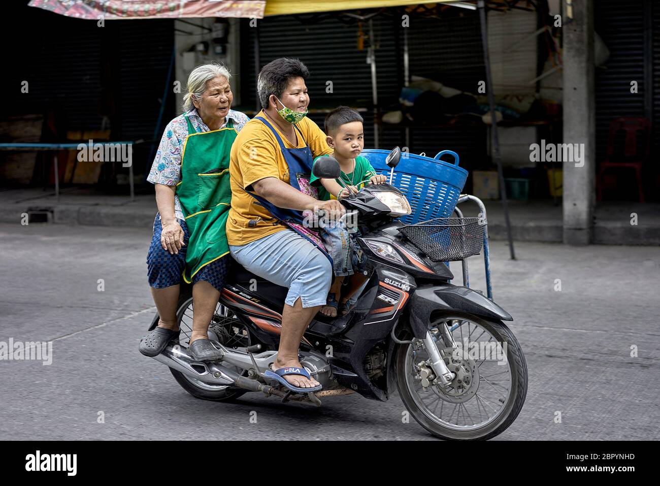 Thailand family. Three generations riding a motorcycle. Mother, adult ...
