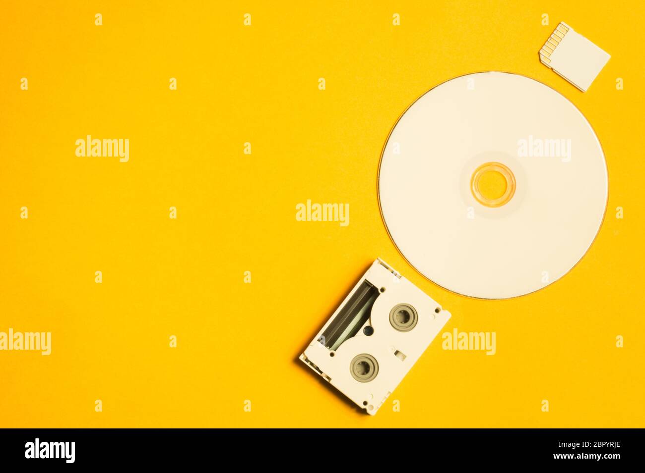 Compact disc and memory card on yellow background. digital video ...