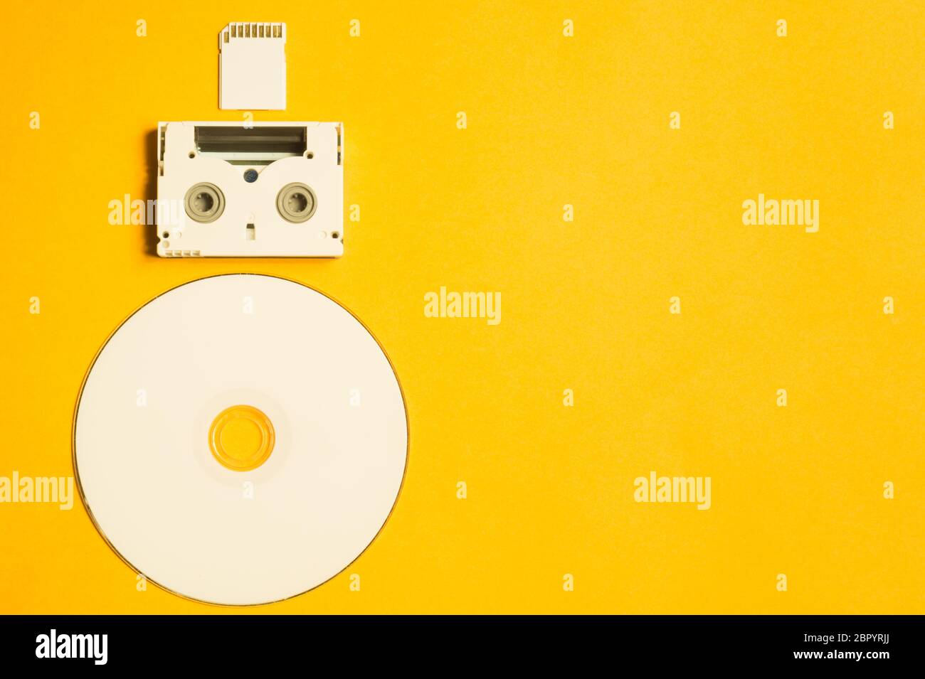 Compact disc and memory card on yellow background. digital video ...