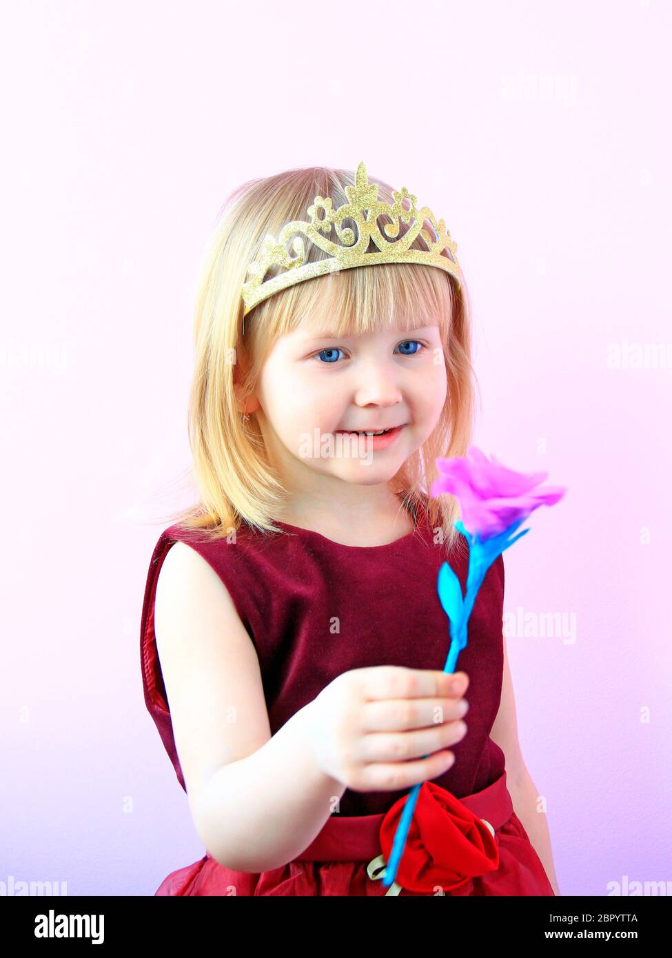Little girl in crown giving flower. Little princess with pink flower ...
