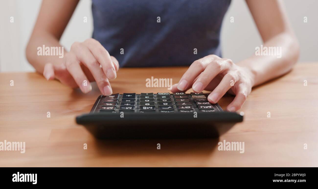 Woman use of calculator at home Stock Photo - Alamy