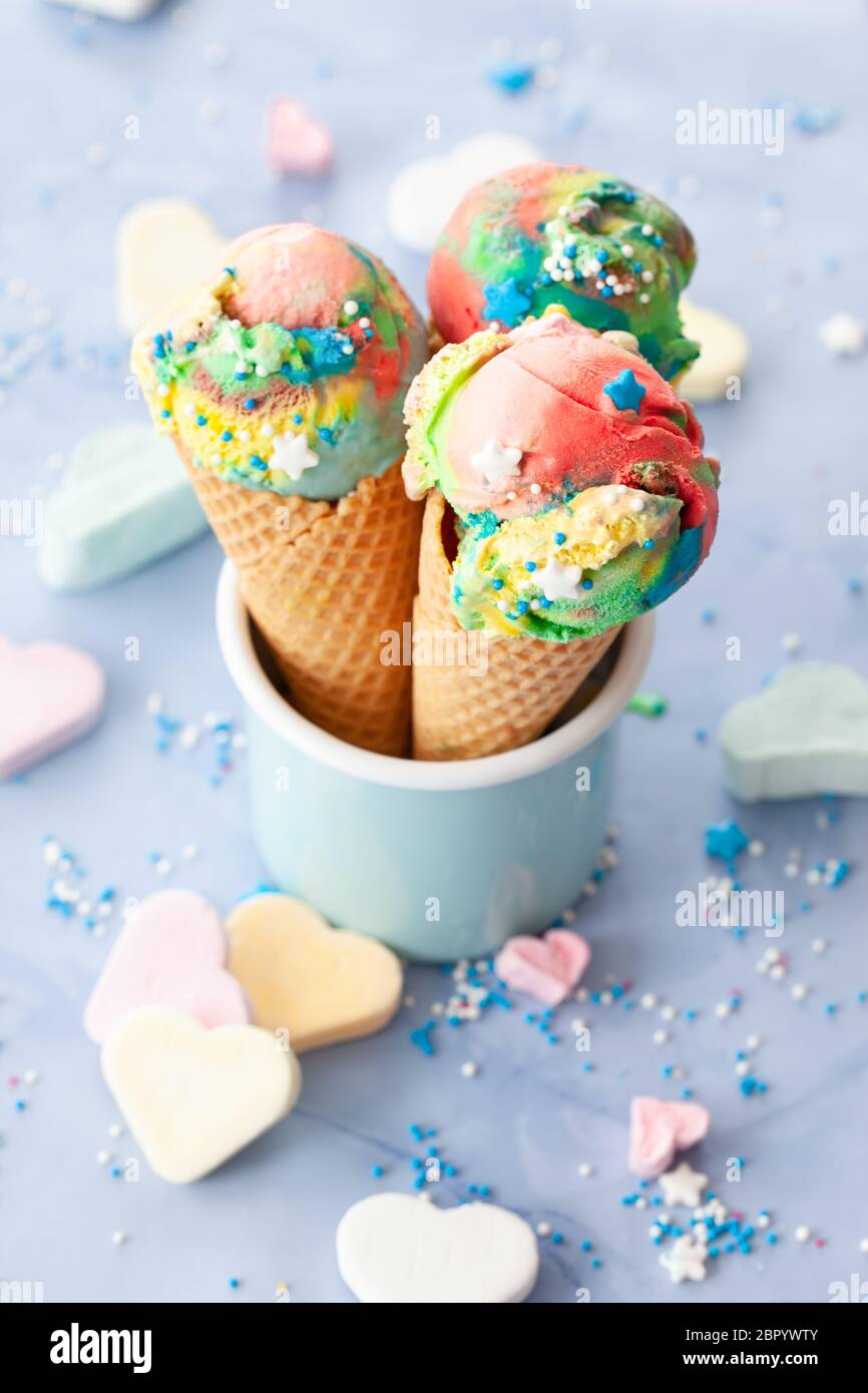 Ice cream cones in rainbow colors with colorful candy Stock Photo - Alamy