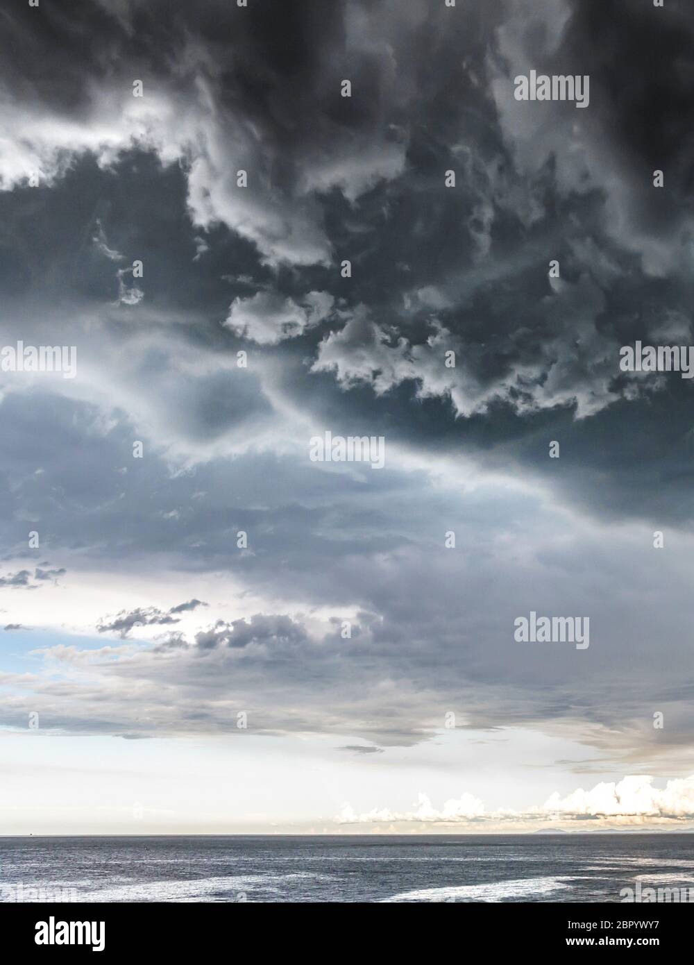Landscape photo of a beach and dramatic thunderstorm clouds over the ...