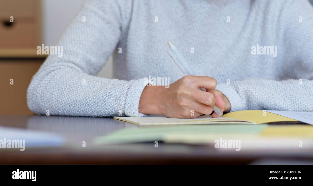 Woman write on note book at home Stock Photo - Alamy