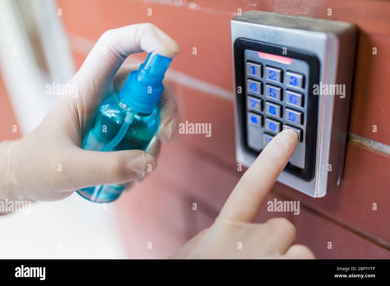Hand in surgical gloves using spray bottle disinfectant and pressing ...