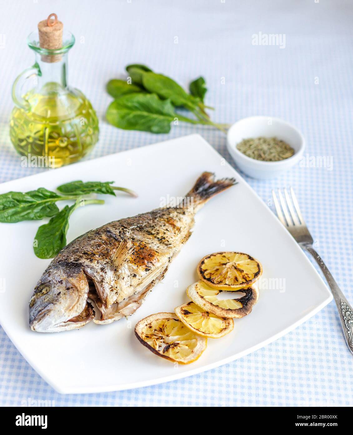 Grilled dorada fish with lemon and spinach Stock Photo - Alamy