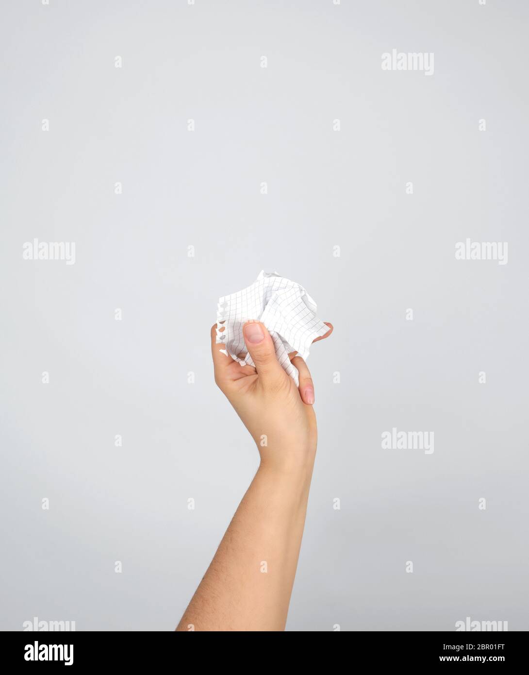 female hand holding white crumpled paper on gray background Stock Photo ...