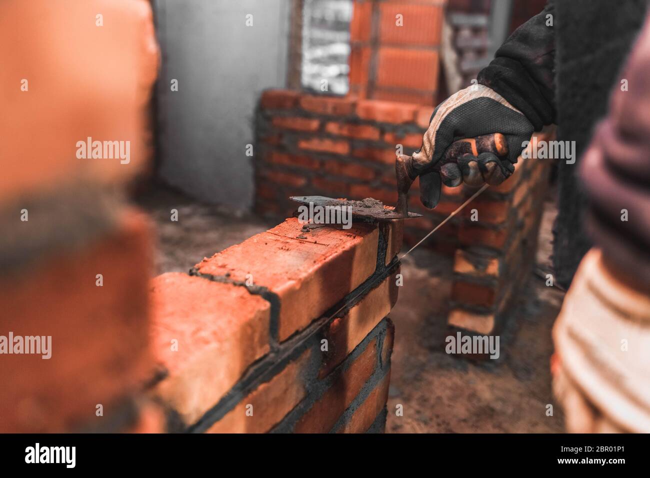 Bricklayer puts bricks to make a wall Stock Photo - Alamy