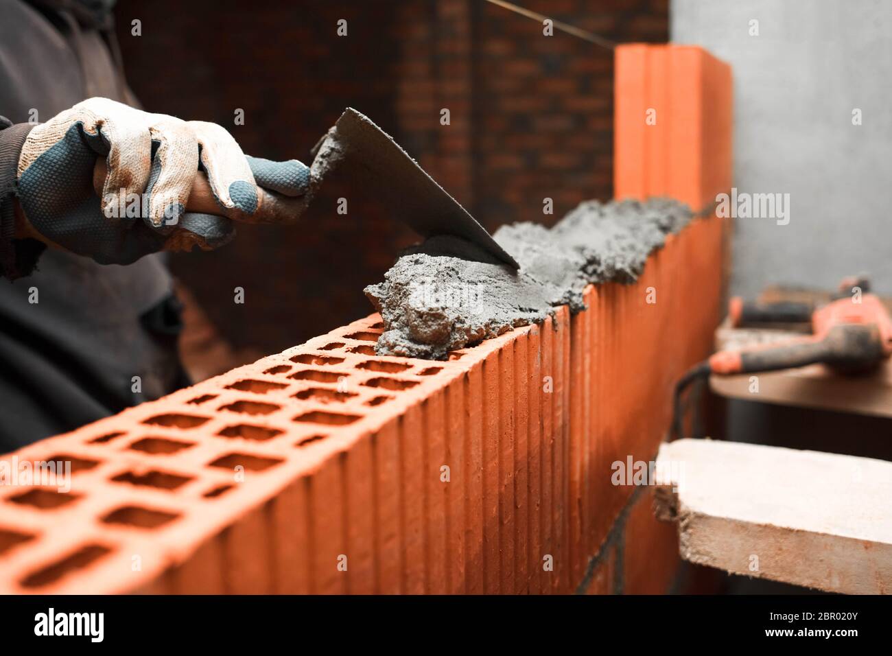 Bricklayer puts bricks to make a wall Stock Photo - Alamy
