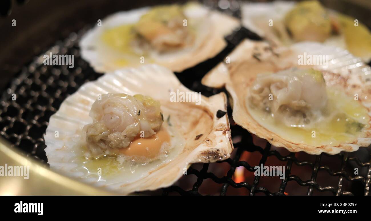 Scallop on metal net barbecue in restaurant Stock Photo - Alamy