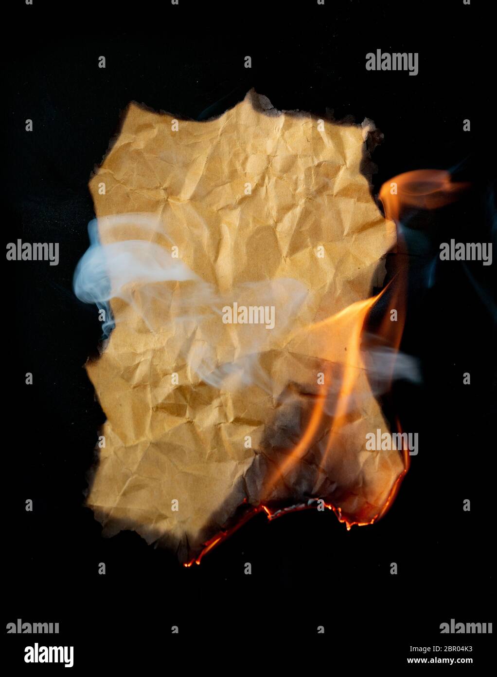 burning piece of crumpled paper on black background Stock Photo - Alamy