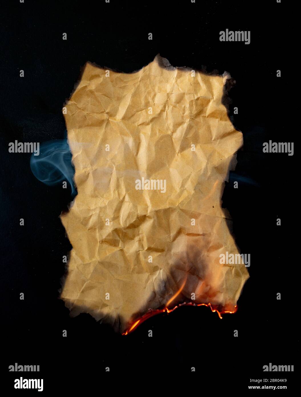 burning piece of crumpled paper on black background Stock Photo - Alamy