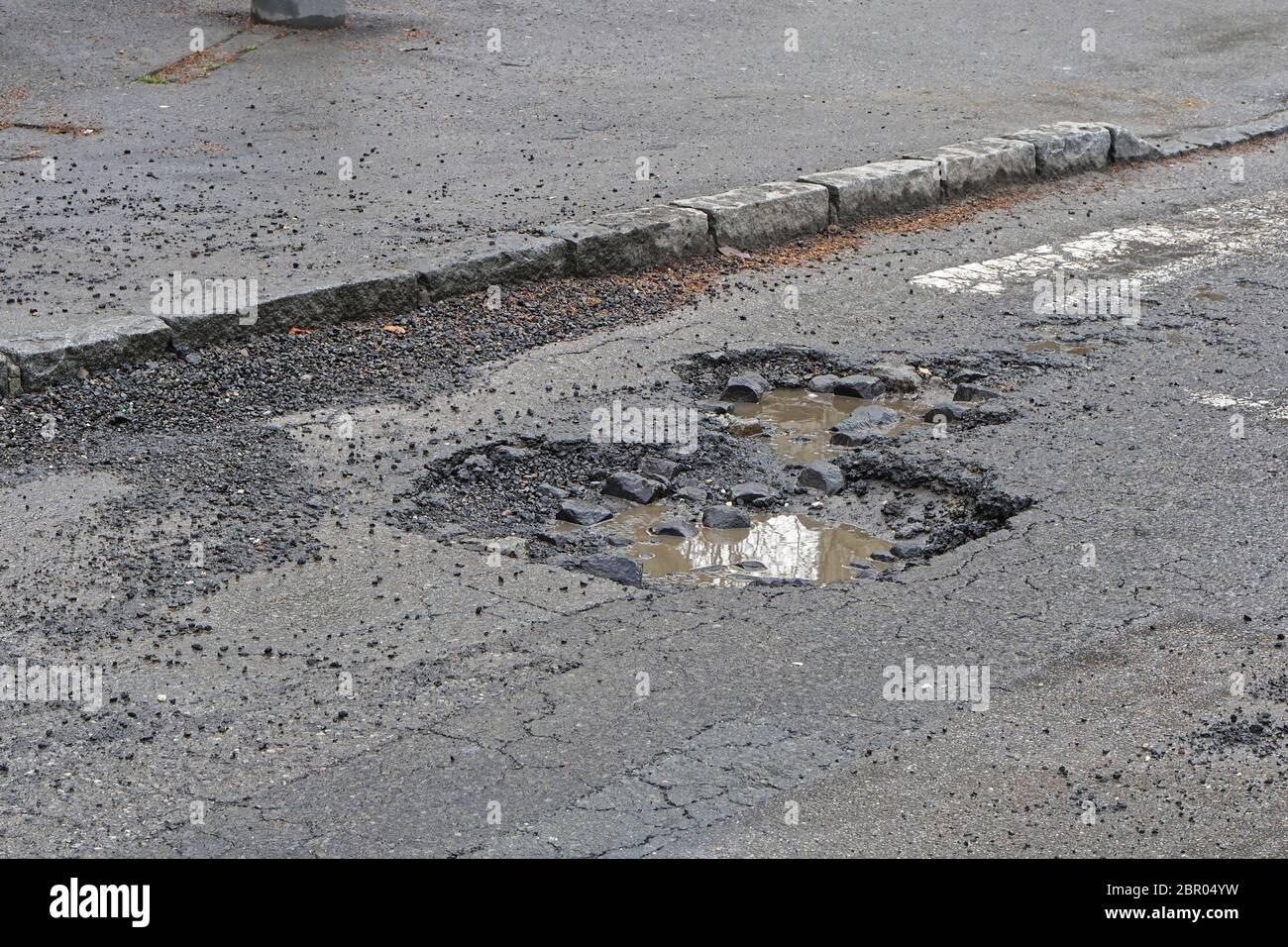 Very big pot hole filled with water at street Stock Photo - Alamy