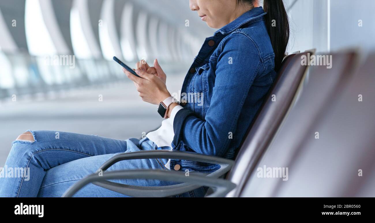 Woman sit down on chair and use of mobile phone Stock Photo - Alamy