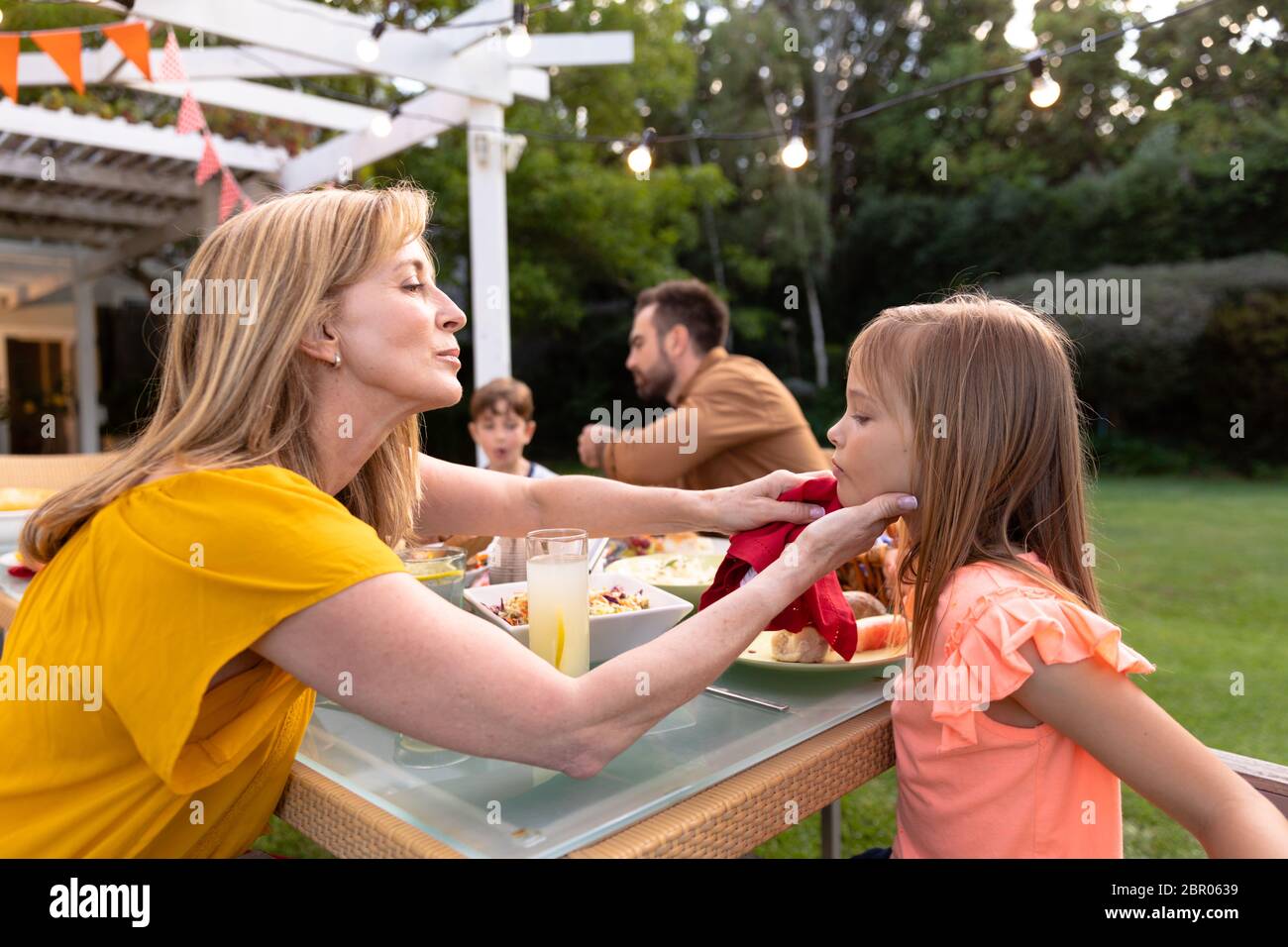 Happy family eating together at table Stock Photo - Alamy